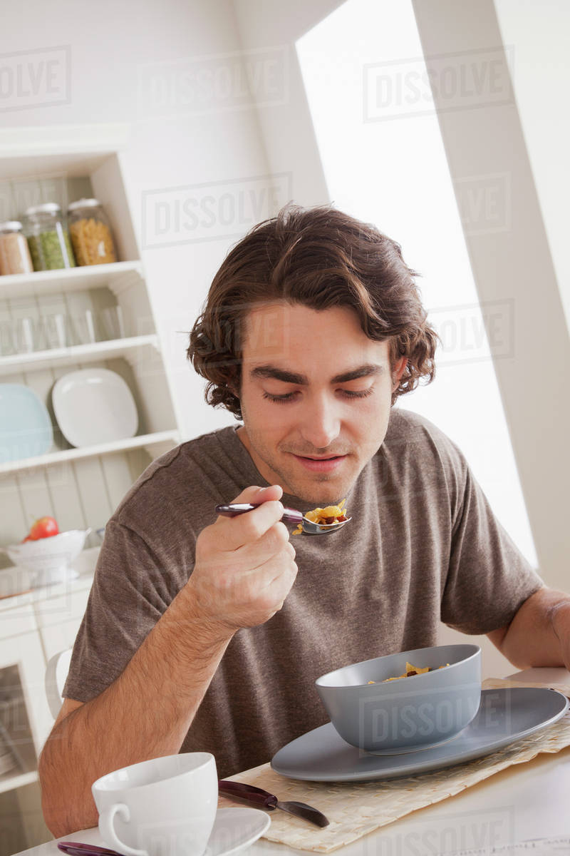 Young man eating - Royalty-free Stock Photo | Dissolve
