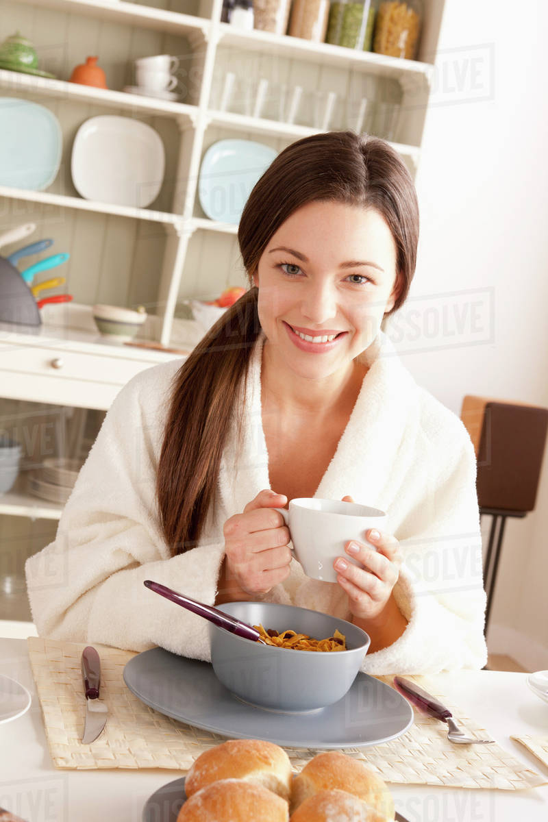 Young smiling woman at breakfast - Stock Photo - Dissolve