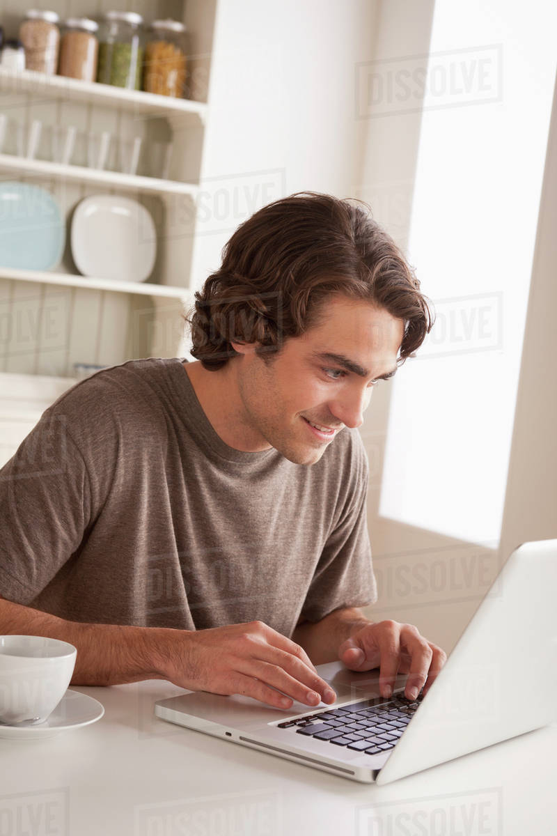 Young man using laptop - Royalty-free Stock Photo | Dissolve