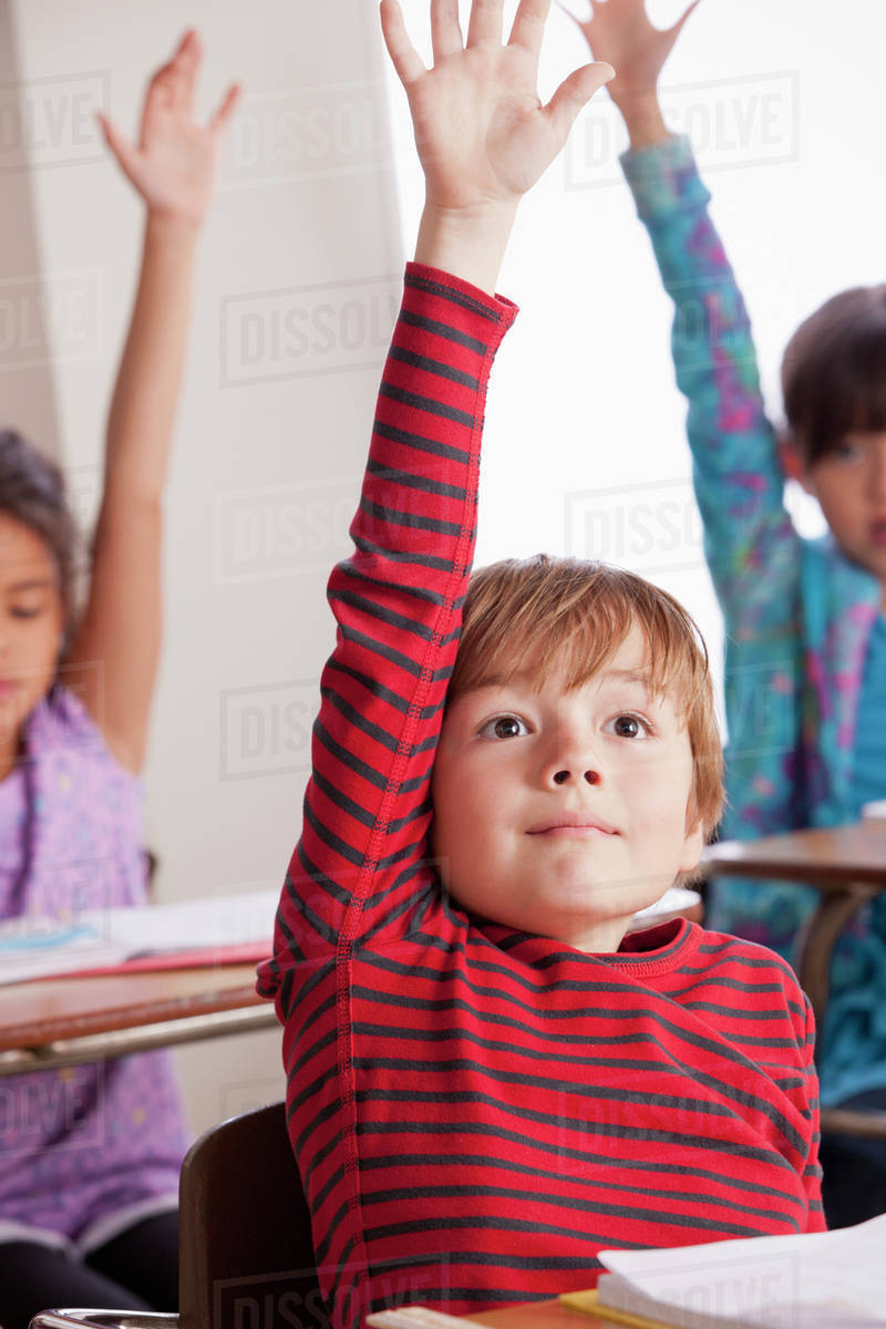 Pupils in classroom raising hands - Stock Photo - Dissolve