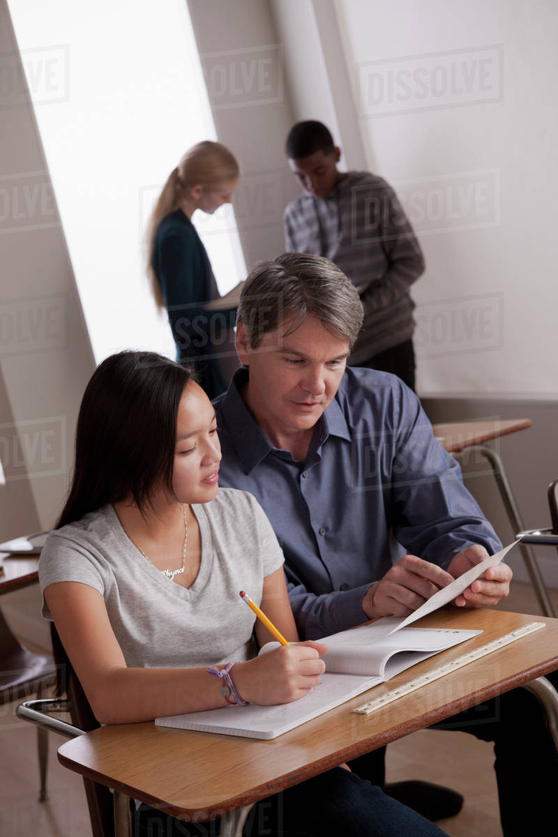 Teacher with teenage students (14-15) at school - Stock Photo - Dissolve