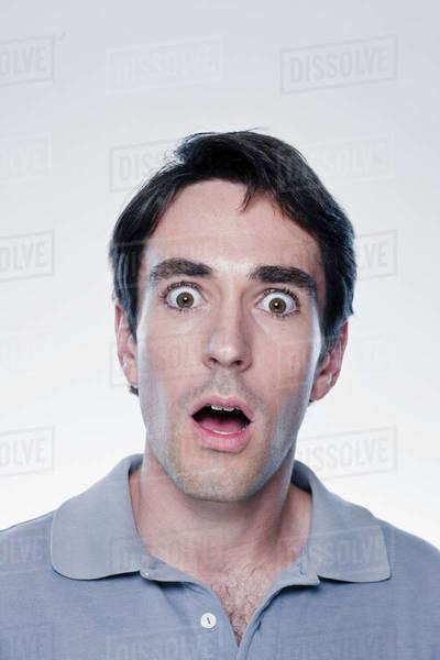 Portrait of scared man, studio shot - Stock Photo - Dissolve