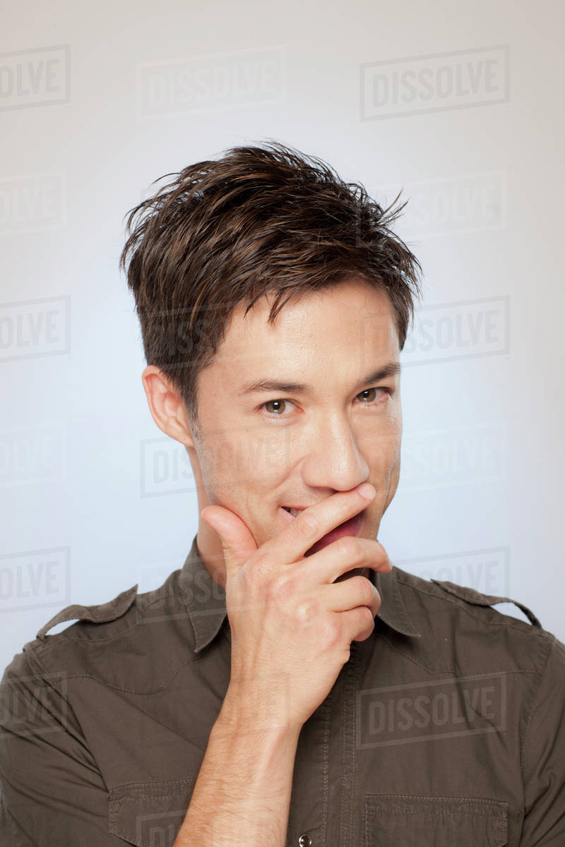 Portrait of man covering his mouth - Royalty-free Stock Photo | Dissolve