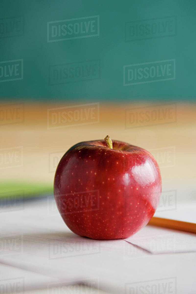 Red apple on teacher's desk - Royalty-free Stock Photo | Dissolve