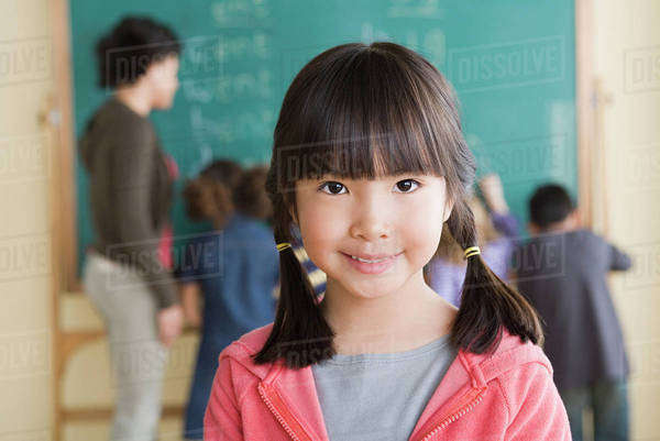 Portrait of smiling girl (6-7) with classmates in background - Stock ...