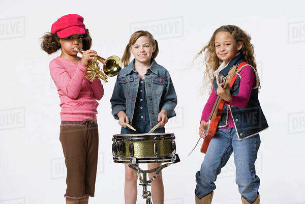 Three girls (8-9) playing instruments together, studio shot - Royalty ...