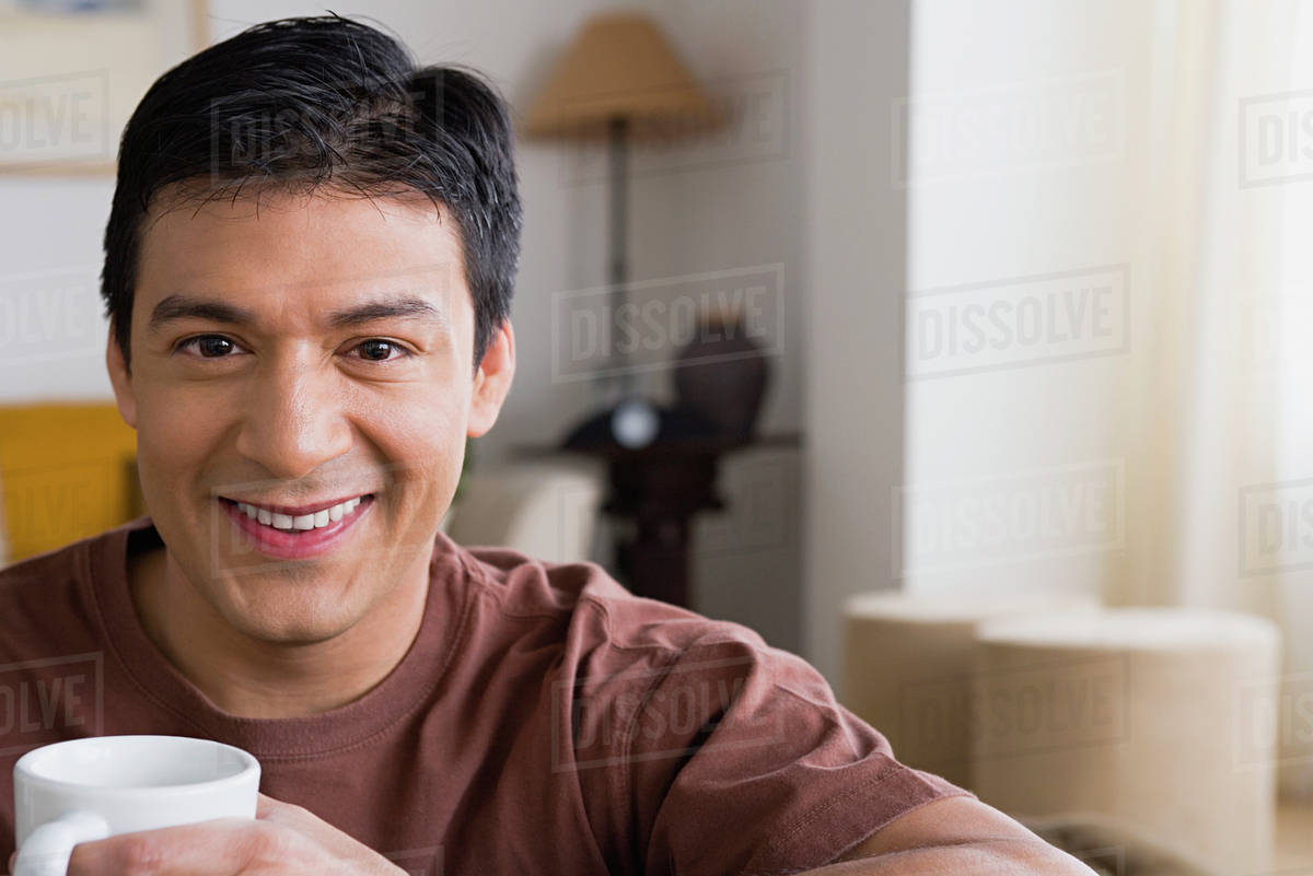 Portrait of smiling man with cup - Stock Photo - Dissolve