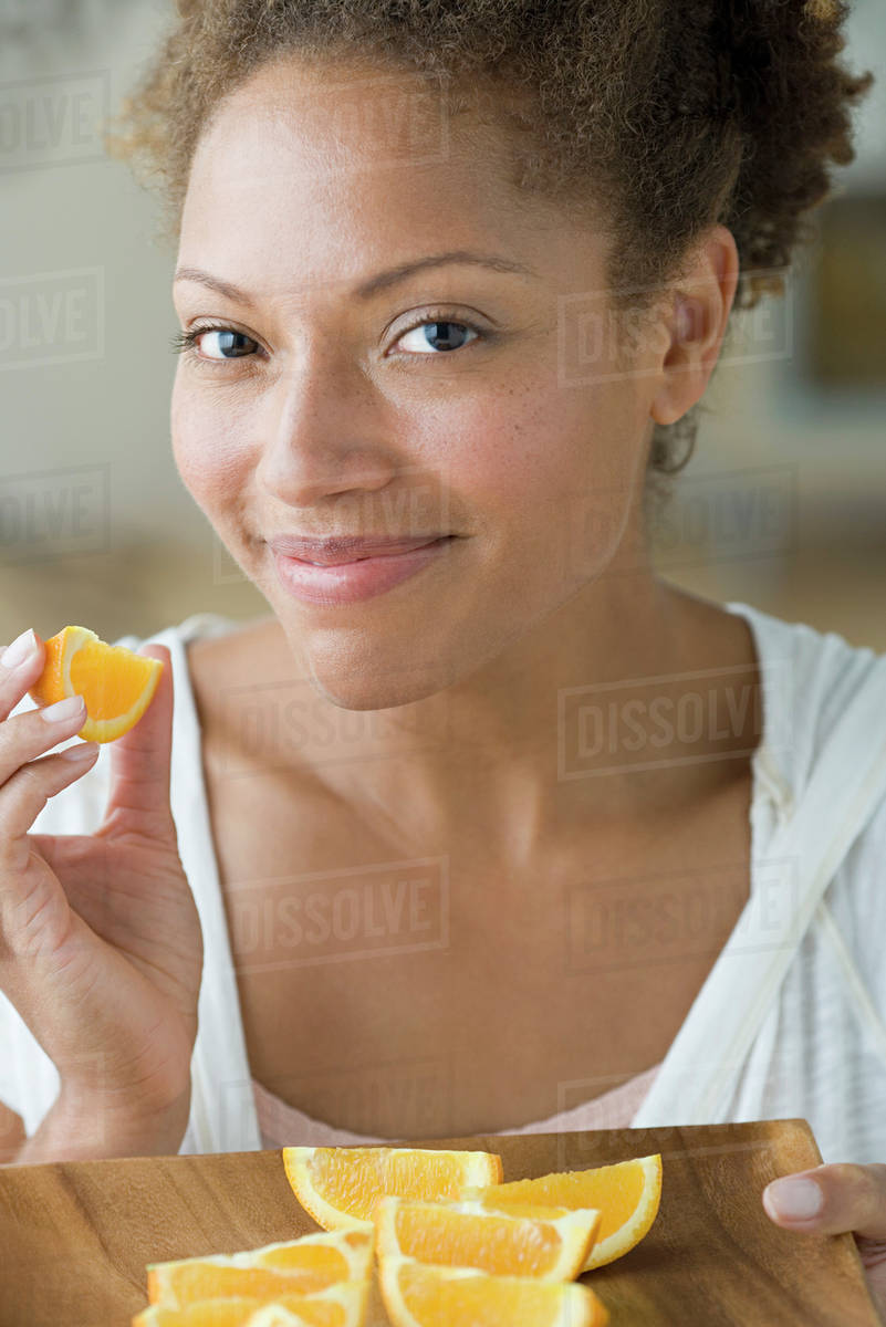 Portrait of attractive woman eating orange - Royalty-free Stock Photo ...