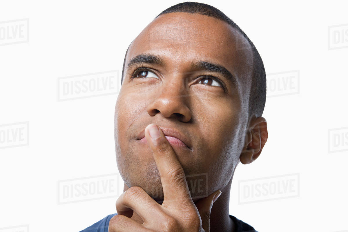 Studio portrait of young man contemplating - Stock Photo - Dissolve