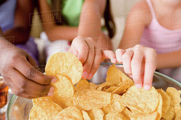 Three girls (10-11) reaching for crisps - Royalty-free Stock Photo ...