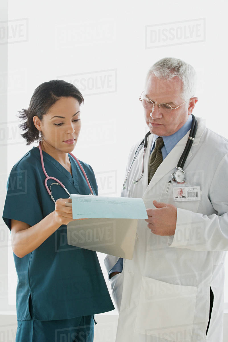 Two doctors reading document - Stock Photo - Dissolve