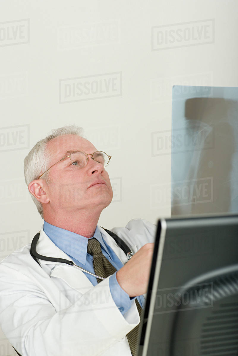 Doctor looking at x-ray image - Royalty-free Stock Photo | Dissolve
