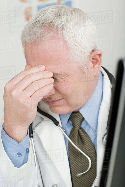 Doctor rubbing forehead - Royalty-free Stock Photo | Dissolve