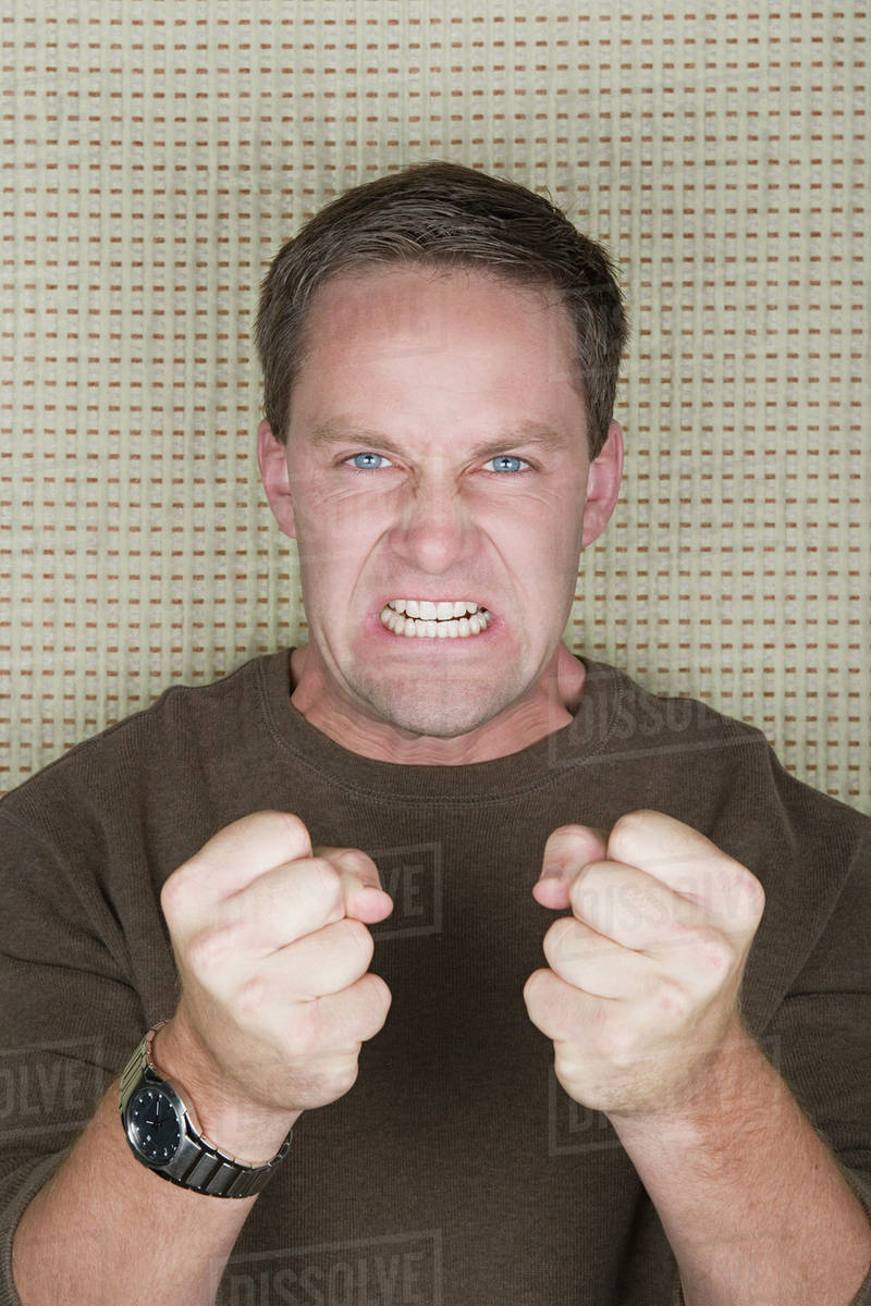 Studio portrait of mature man clenching teeth and fists - Stock Photo ...