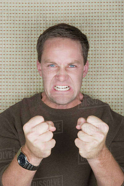 Studio portrait of mature man clenching teeth and fists - Stock Photo ...