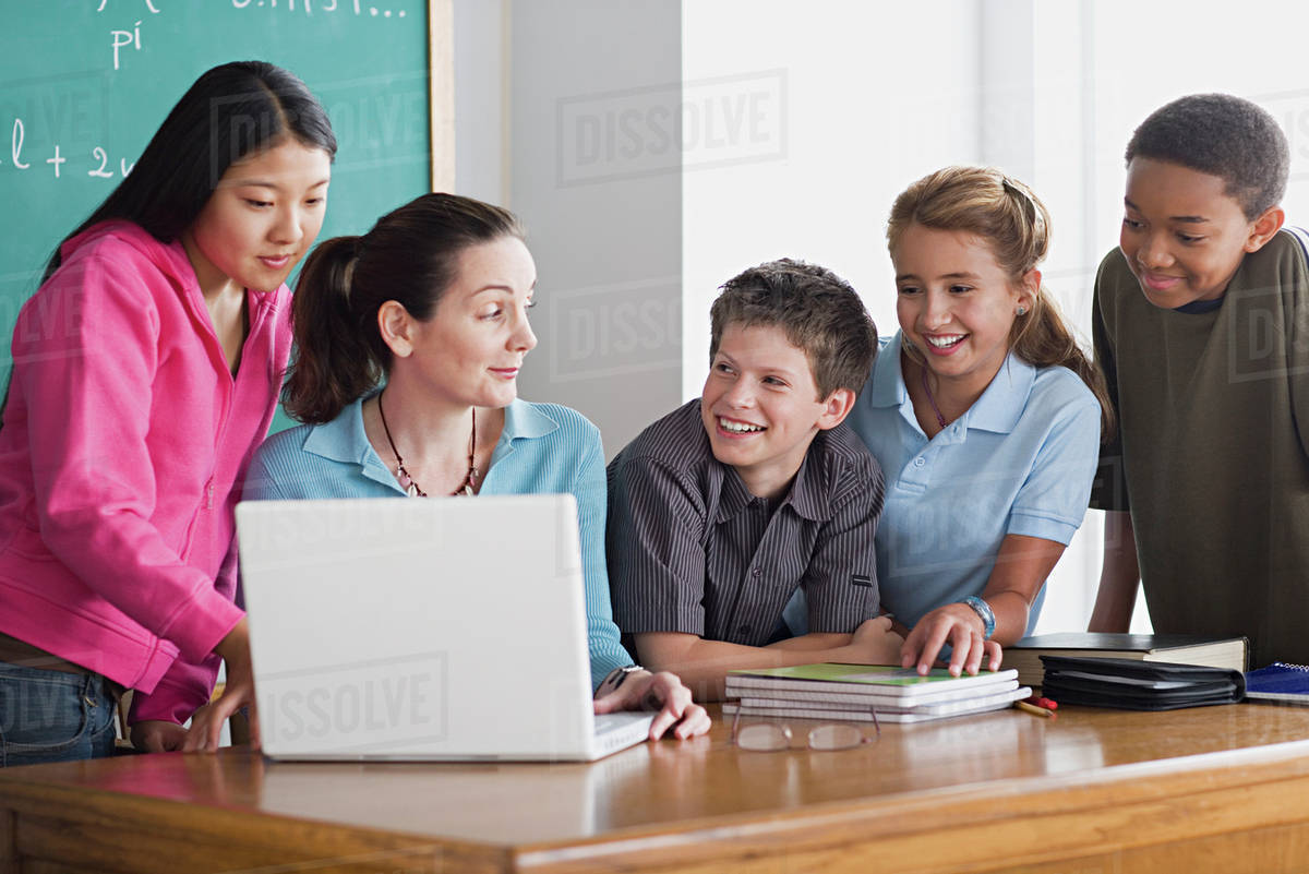 Group of school children with teacher using laptop - Royalty-free Stock ...