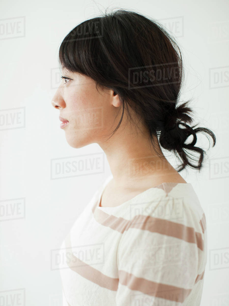 Side view of young woman, studio shot - Stock Photo - Dissolve