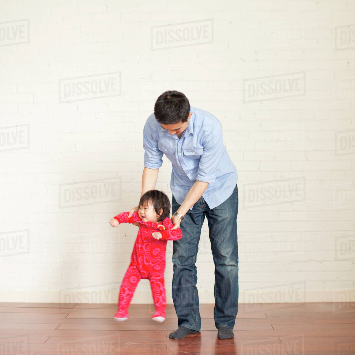 Father helping baby girl (12-17 months) with her first steps - Royalty ...