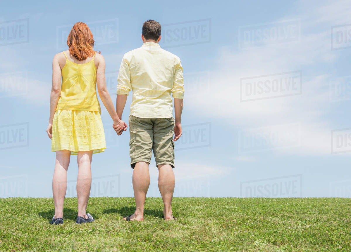 Couple standing on meadow - Royalty-free Stock Photo | Dissolve
