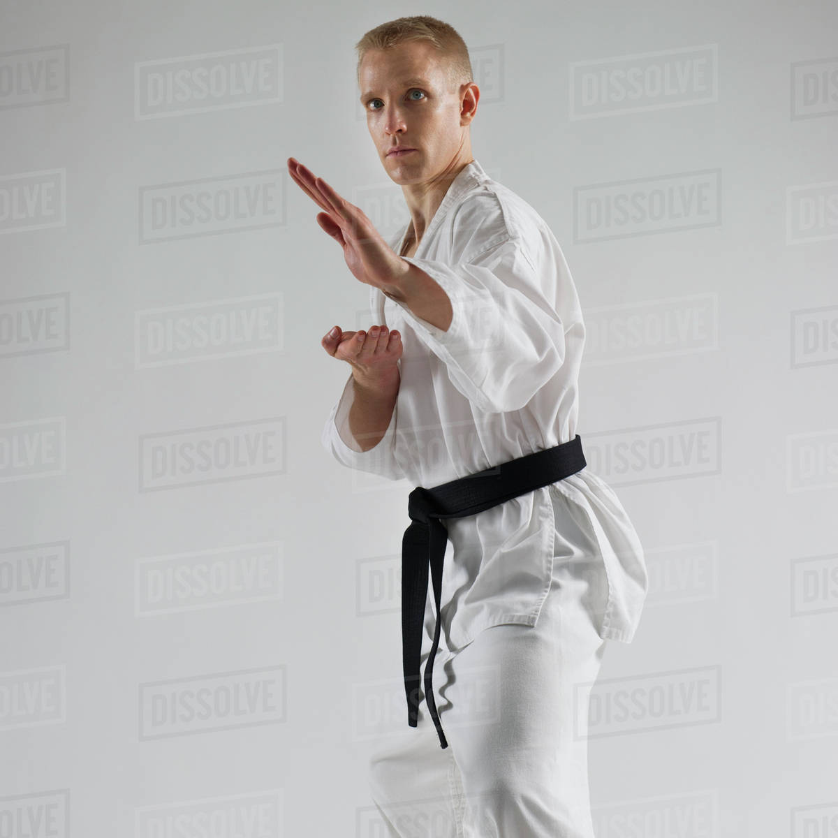 Young man performing karate stance on white background - Stock Photo ...