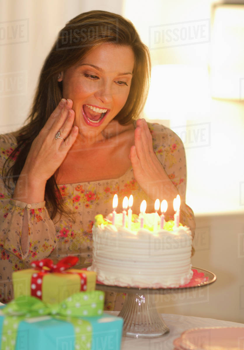 Woman looking at birthday cake - Royalty-free Stock Photo | Dissolve