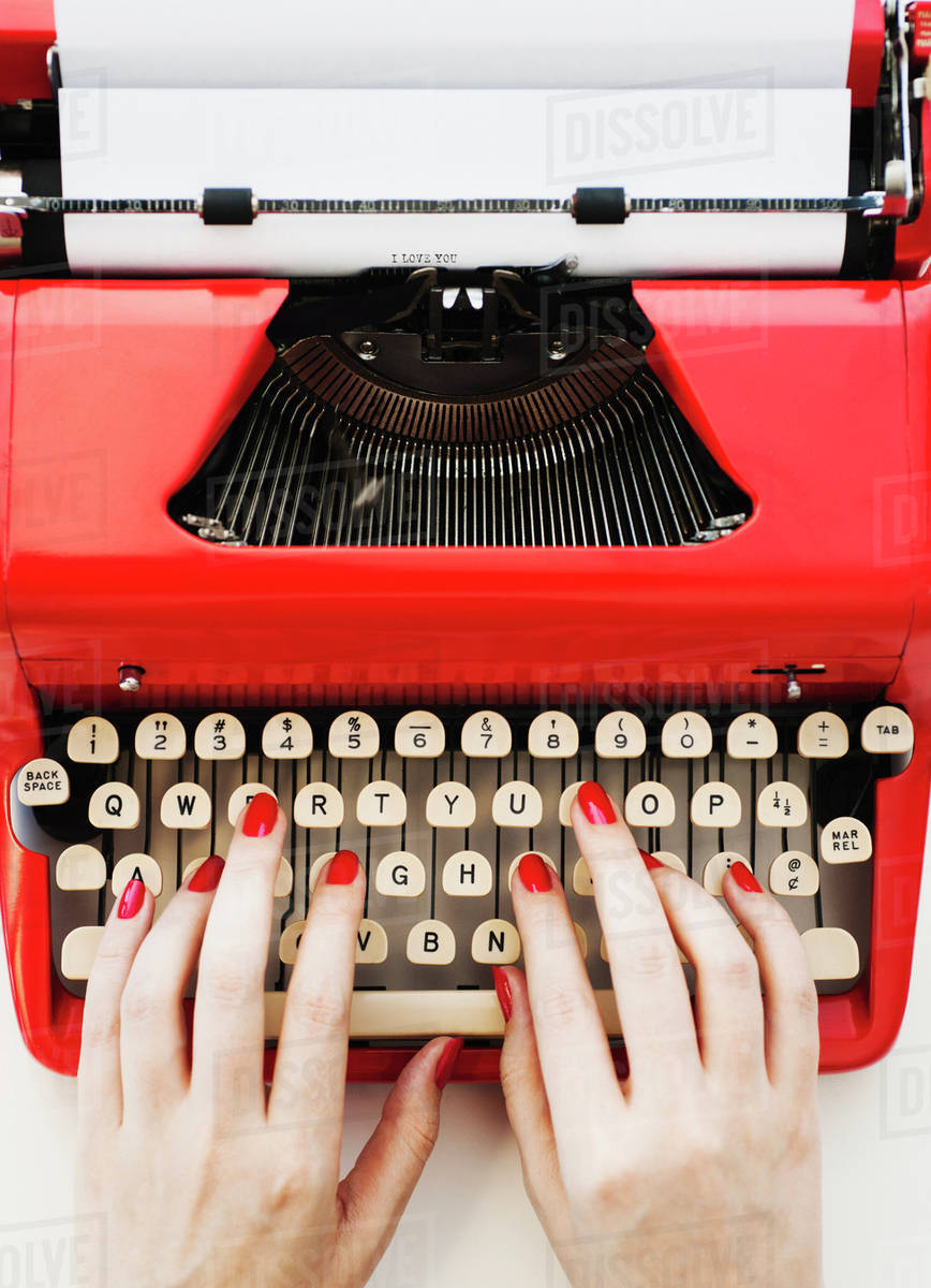 Close up of woman's hands with red nail polish typing on antique ...
