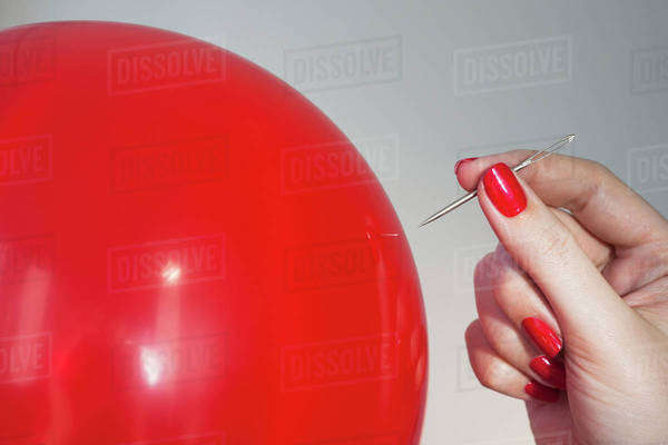 Close up of red balloon and woman's hand holding needle - Royalty-free ...
