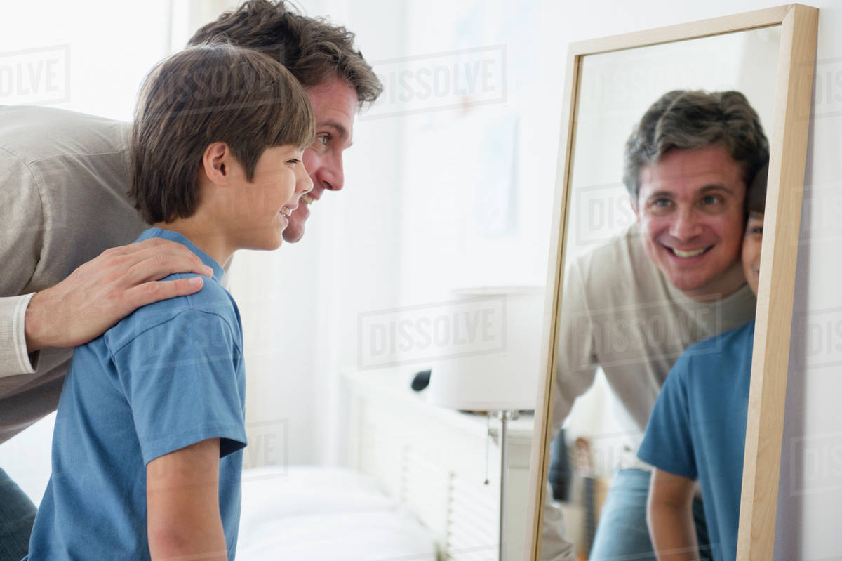 Father and son (8-9) looking into mirror - Royalty-free Stock Photo ...