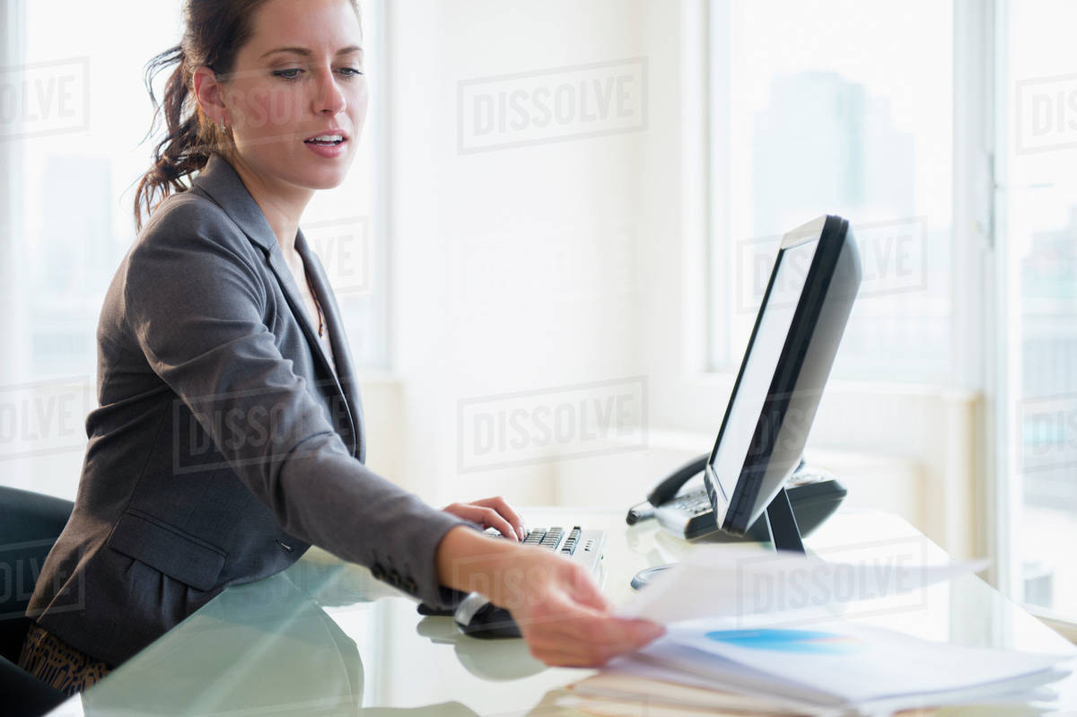 Busy woman in office - Stock Photo - Dissolve