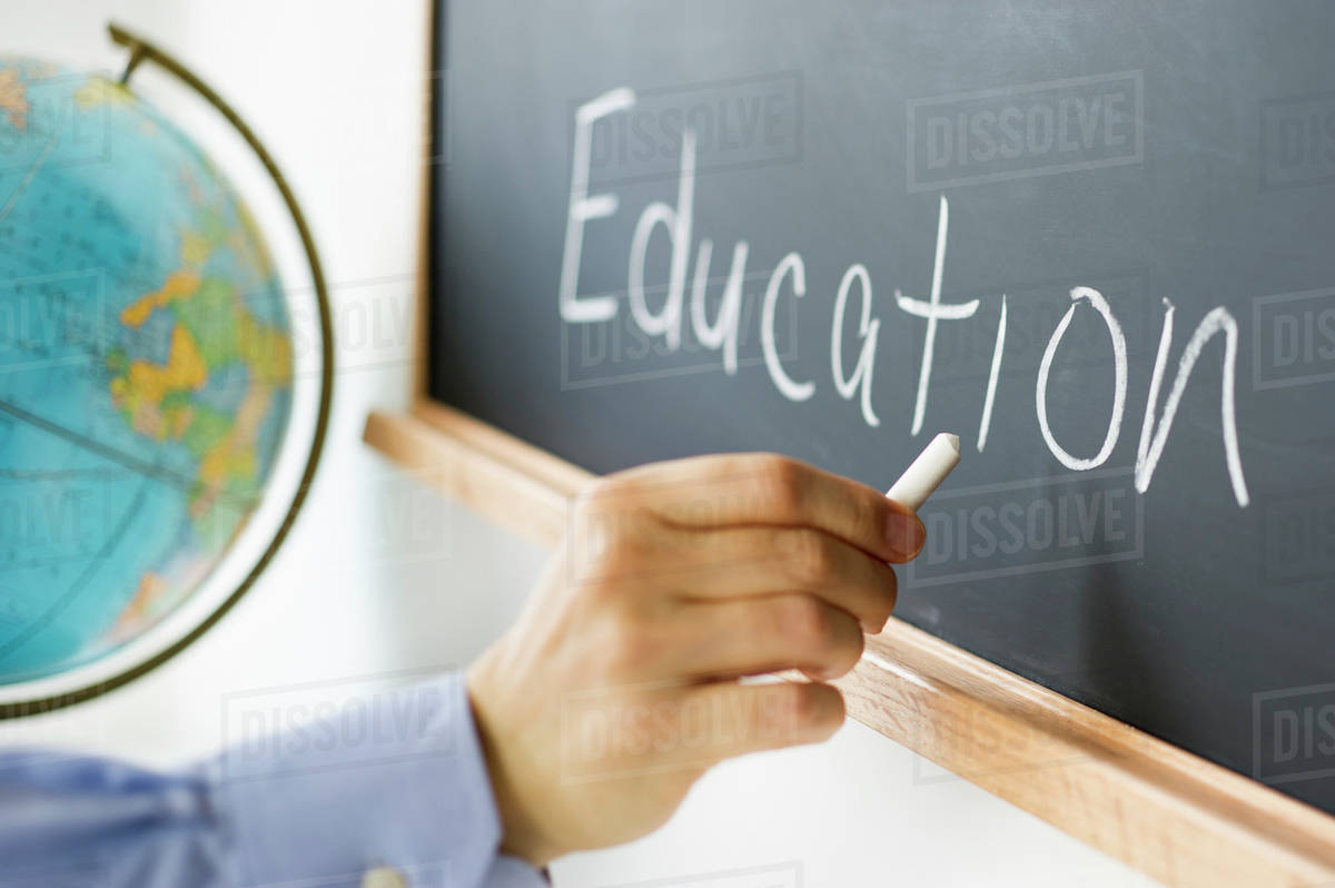 Close-up of man's hand writing "education" on blackboard - Royalty-free ...