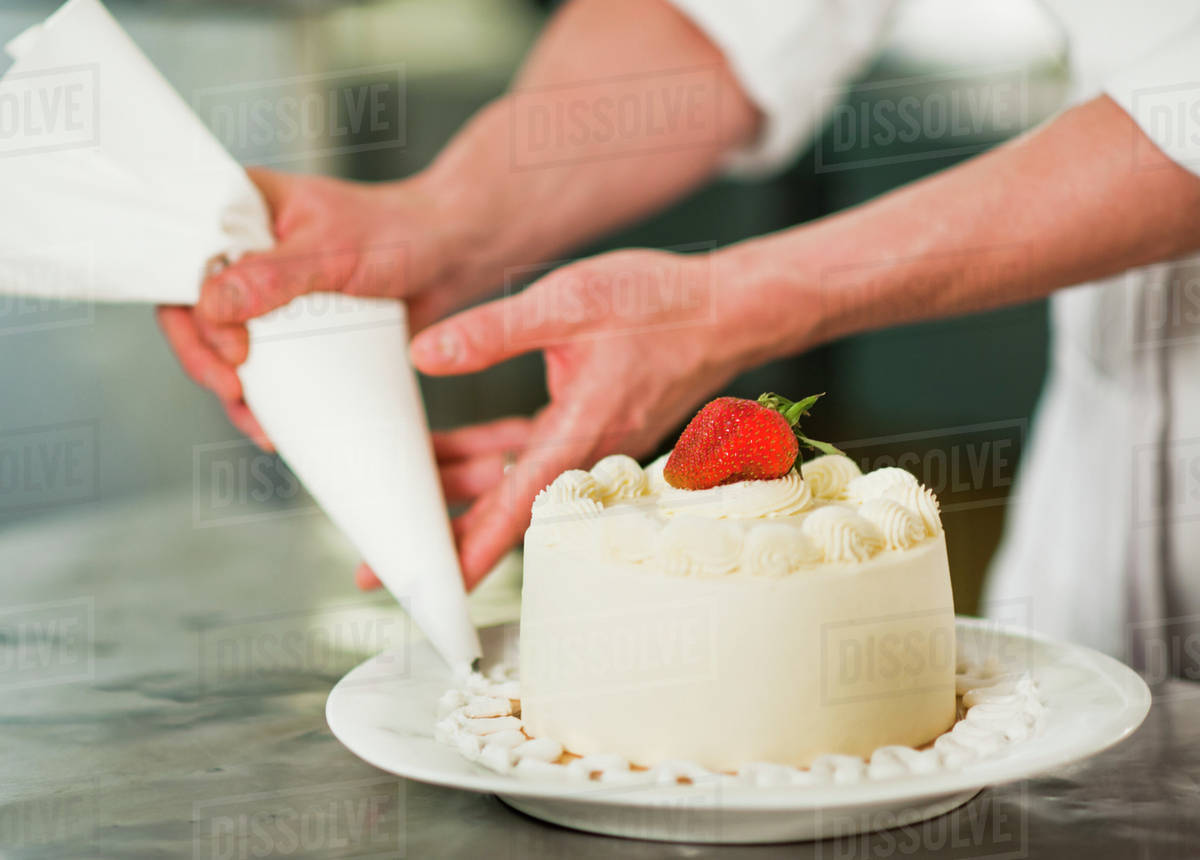 Pastry chef decorating cake - Royalty-free Stock Photo | Dissolve
