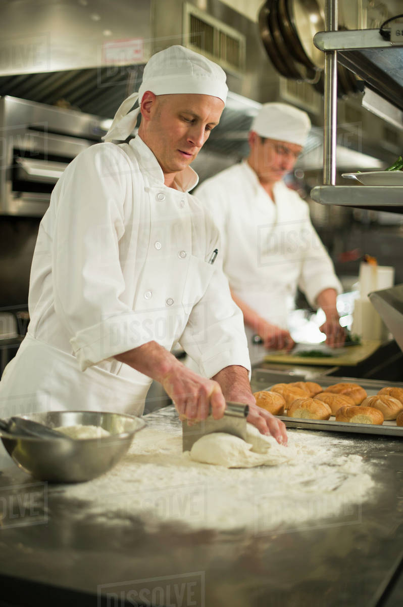 Chef cutting pastry to make rolls - Royalty-free Stock Photo | Dissolve