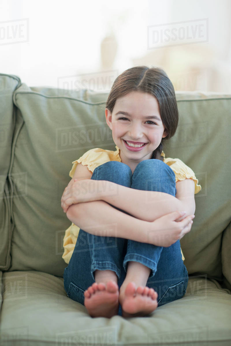Portrait of girl (8-9) sitting on sofa - Royalty-free Stock Photo ...
