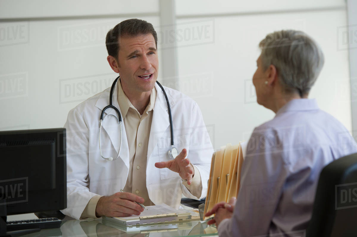 Doctor and female patient sitting in office - Royalty-free Stock Photo ...