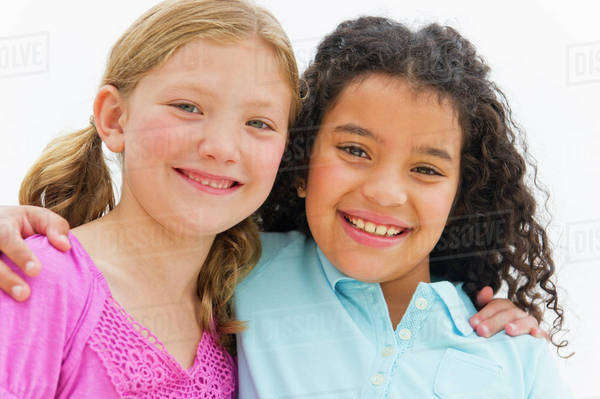 Portrait of two girls (8-9) embracing - Royalty-free Stock Photo | Dissolve
