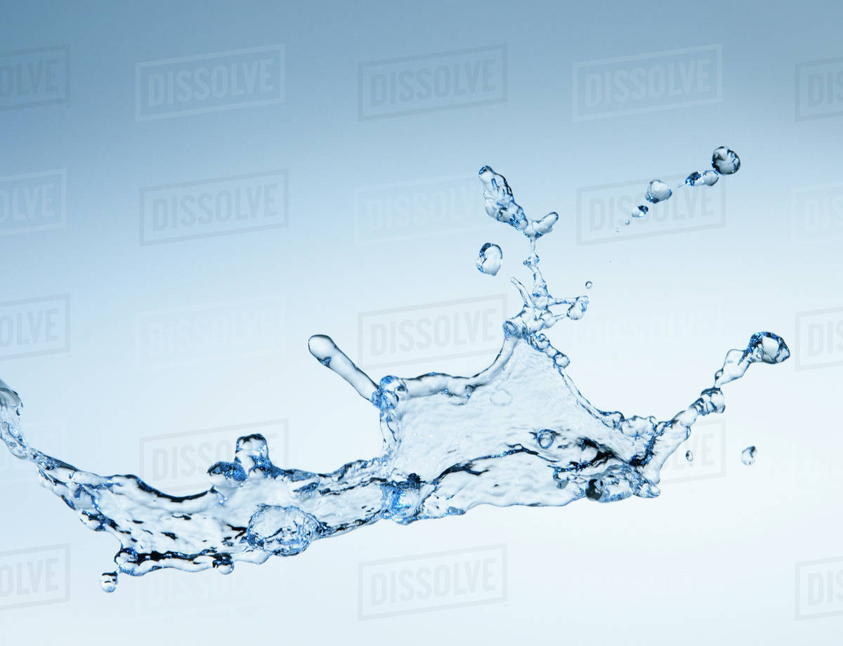 Studio shot of water splash on blue background - Stock Photo - Dissolve