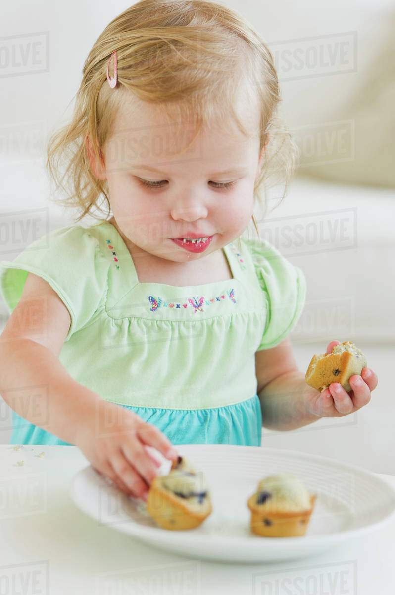Girl (2-3) eating muffins - Royalty-free Stock Photo | Dissolve