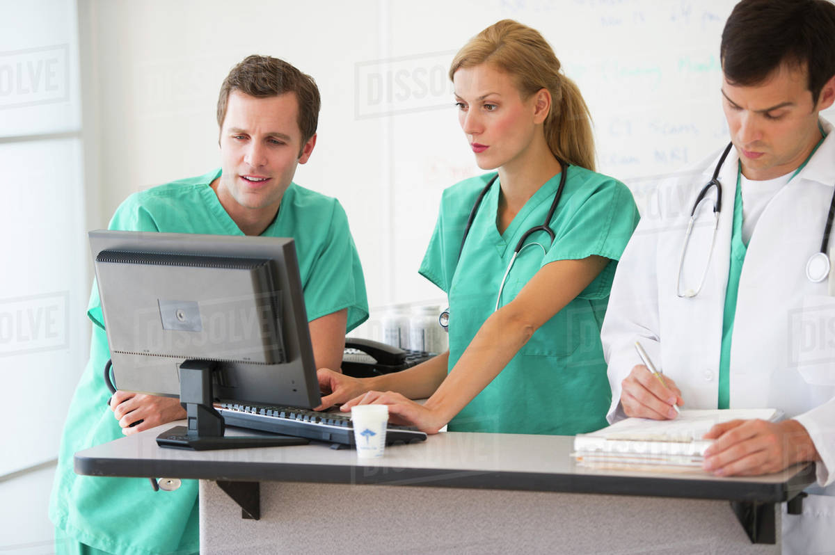 Team of doctors looking at computer - Royalty-free Stock Photo | Dissolve