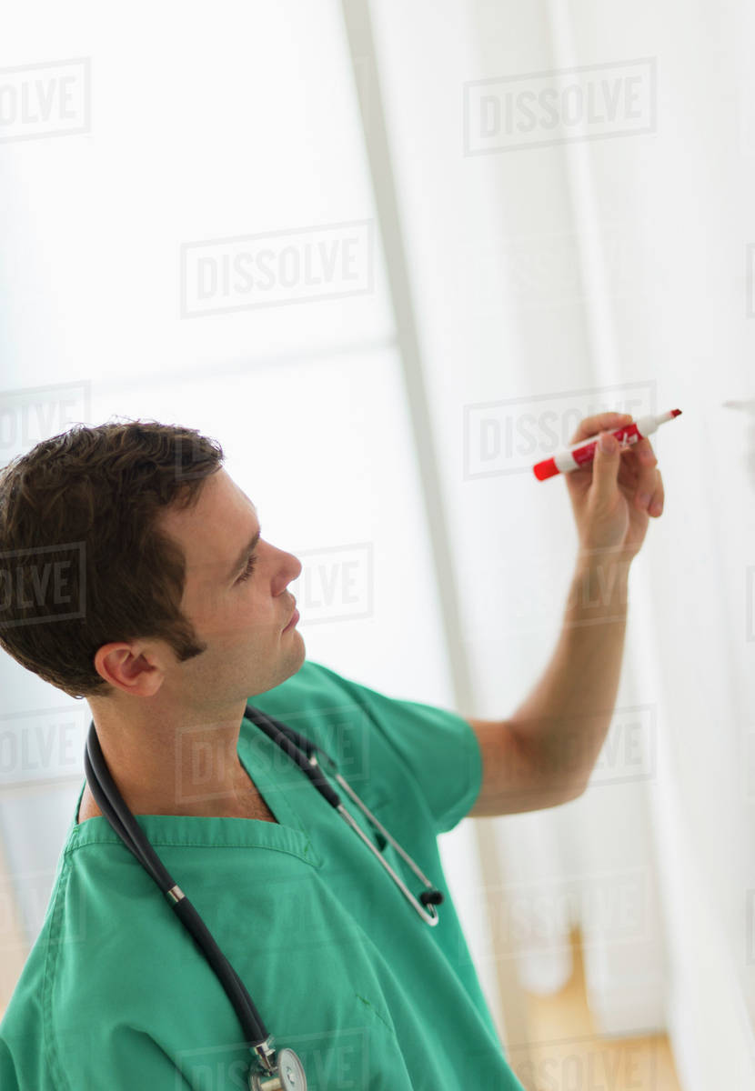 Doctor writing on whiteboard - Stock Photo - Dissolve