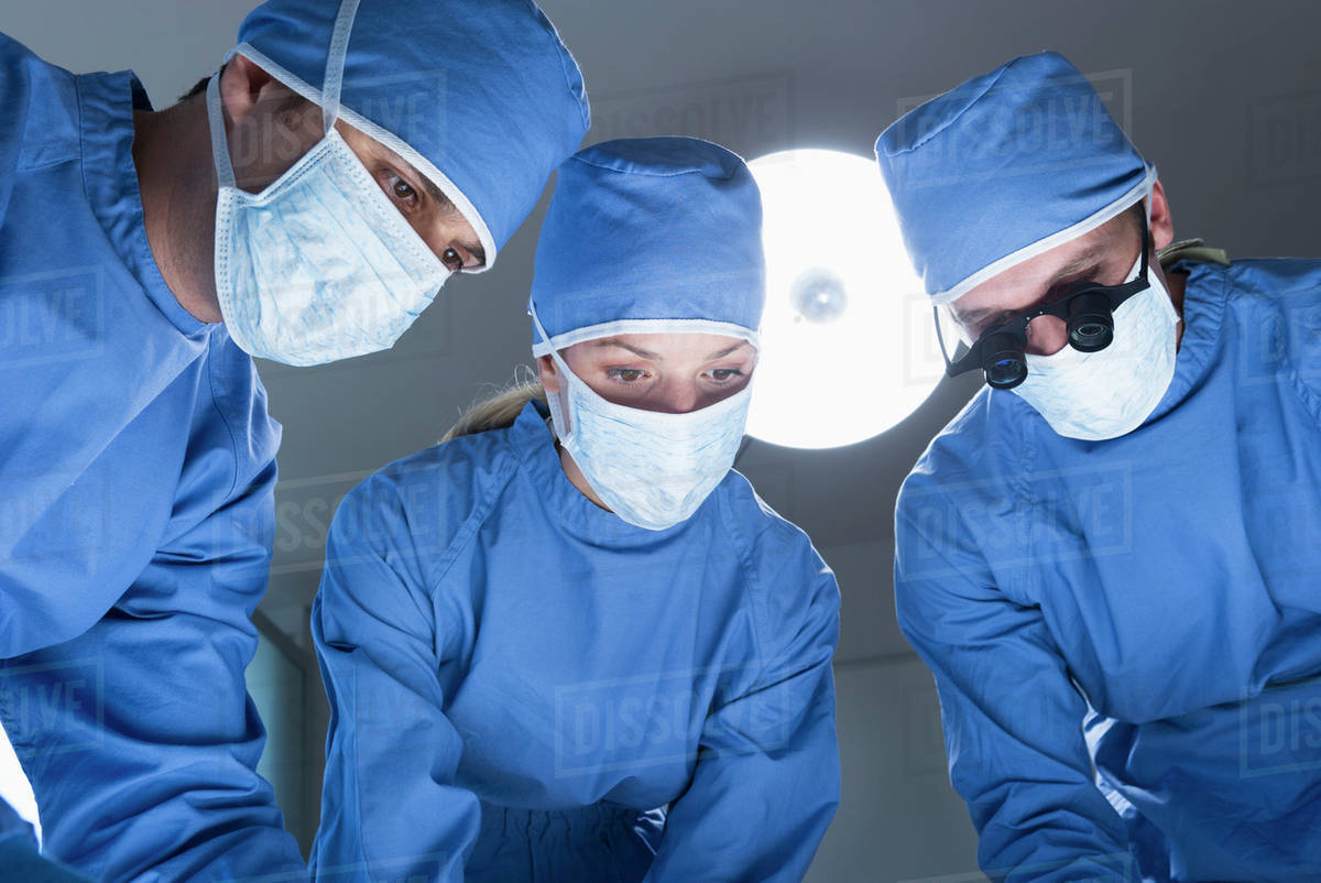 Three surgeons operating - Royalty-free Stock Photo | Dissolve