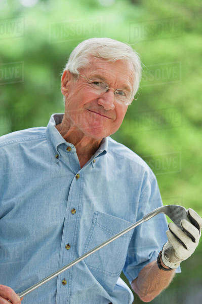Senior man holding golf club, portrait - Royalty-free Stock Photo ...
