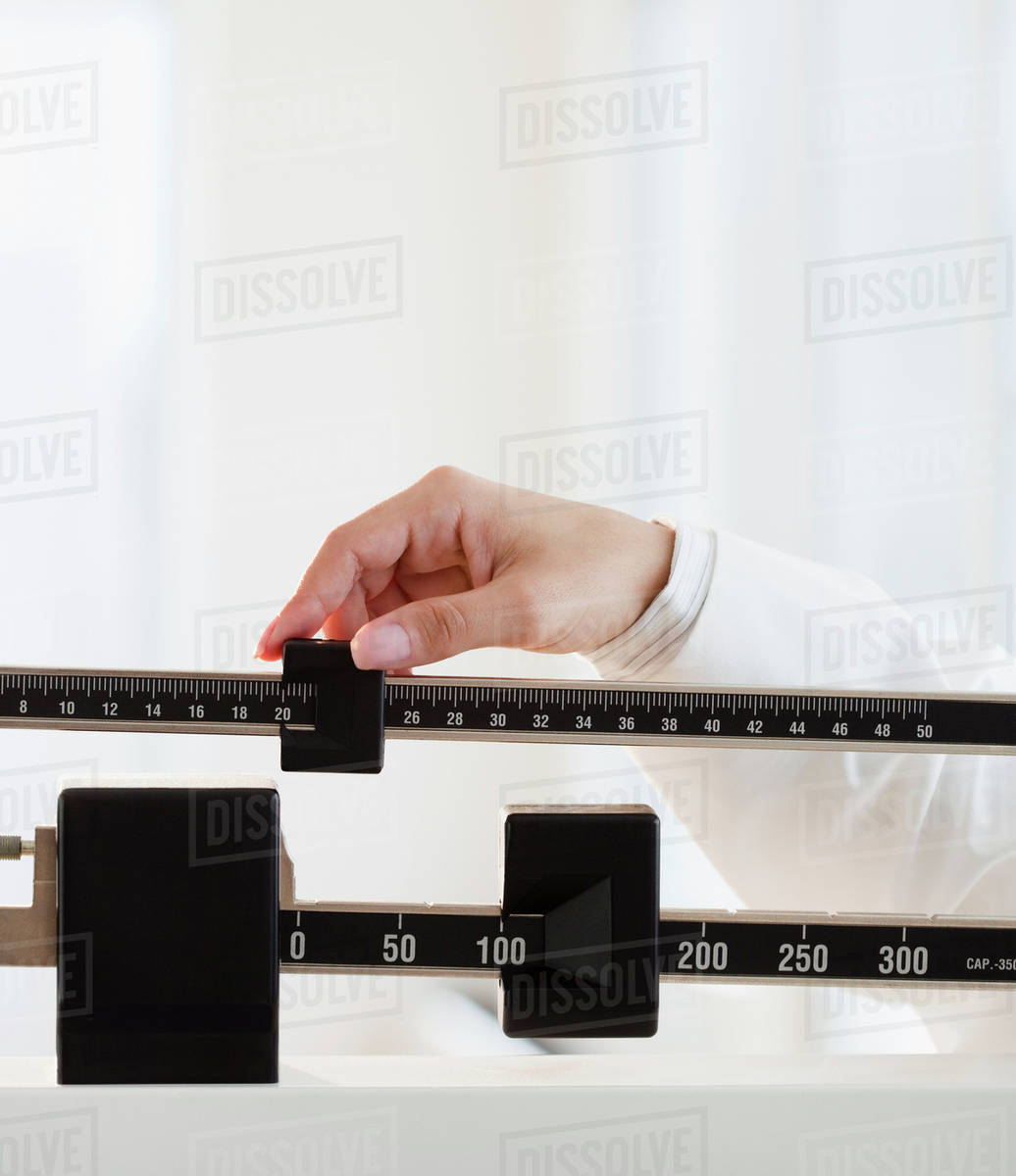 Close up of female doctor's hand holding scale - Stock Photo - Dissolve