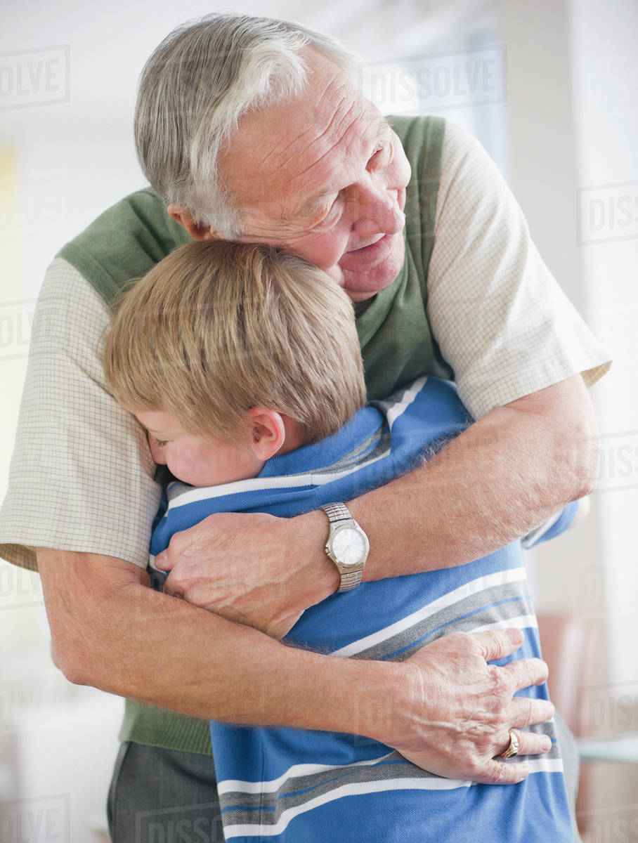 Grandfather hugging grandson (8-9) - Royalty-free Stock Photo | Dissolve