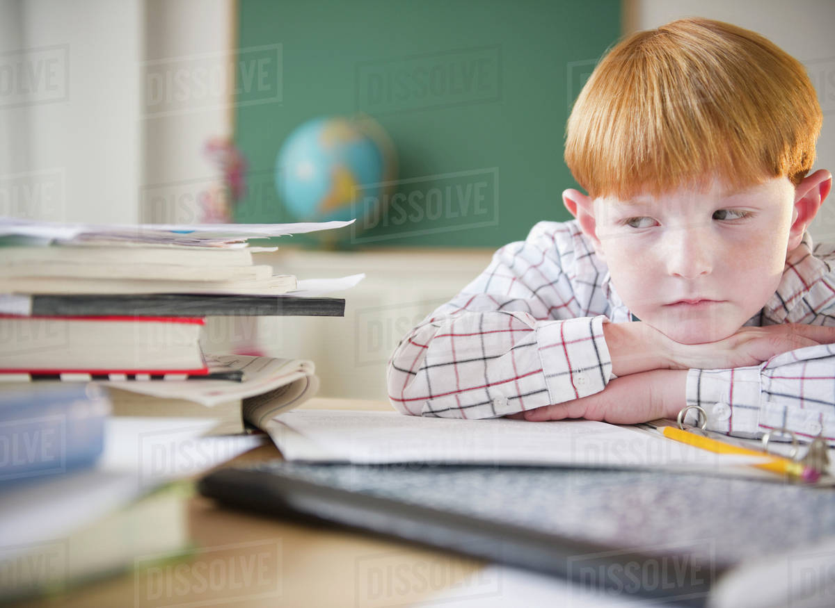 Boy (8-9) sitting at crowded desk in classroom - Royalty-free Stock ...