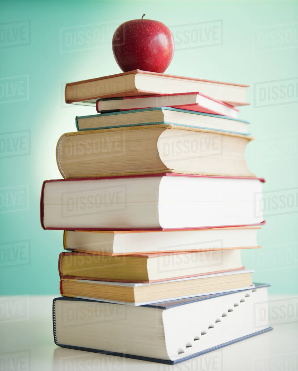 Apple on stack of books - Stock Photo - Dissolve