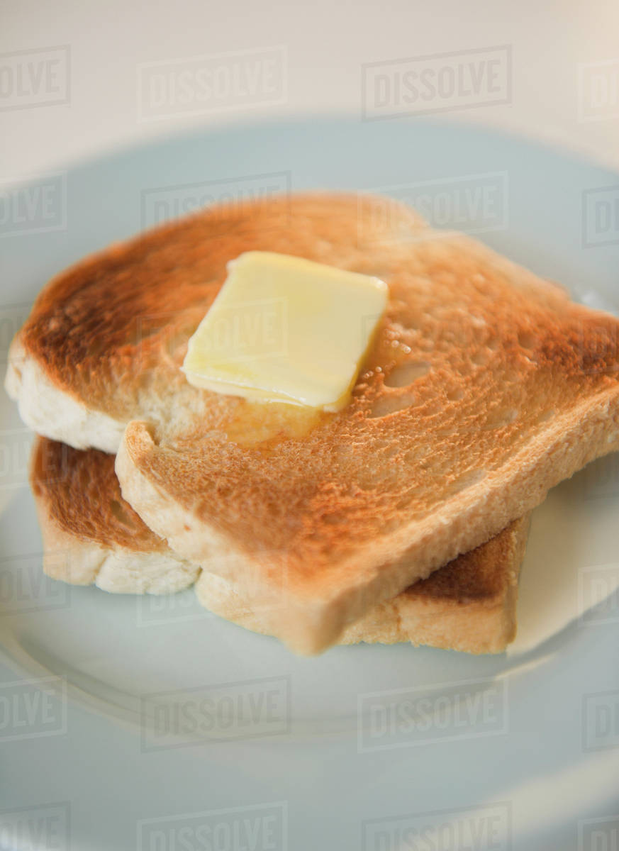 Close up of toasts with butter on plate - Stock Photo - Dissolve