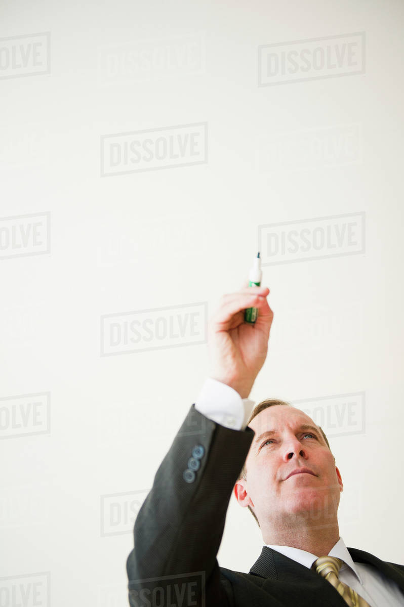 Businessman pointing with pen - Royalty-free Stock Photo | Dissolve