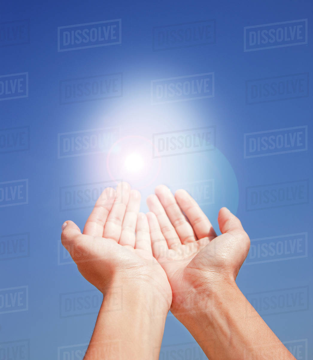 Close up of woman's hands holding sunlight on blue sky - Royalty-free ...