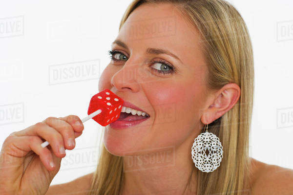 Studio portrait of young woman eating dice lollipop - Royalty-free ...