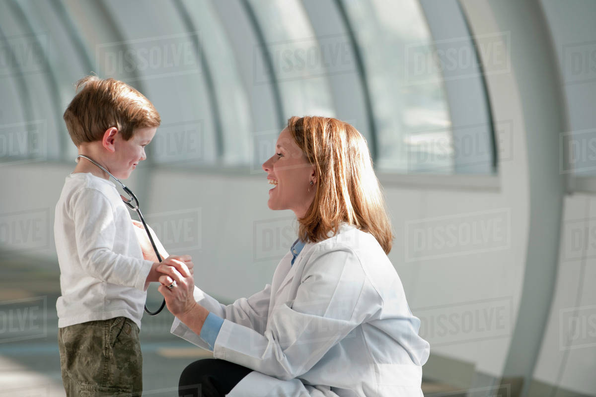 USA, Virginia, Virginia Beach, female doctor talking to boy (6-7) in ...